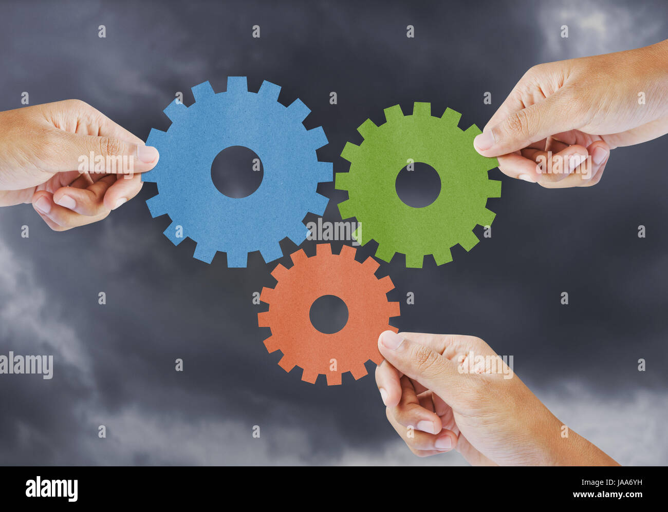 Hand show gear to teamwork as concept in storm clouds Stock Photo - Alamy