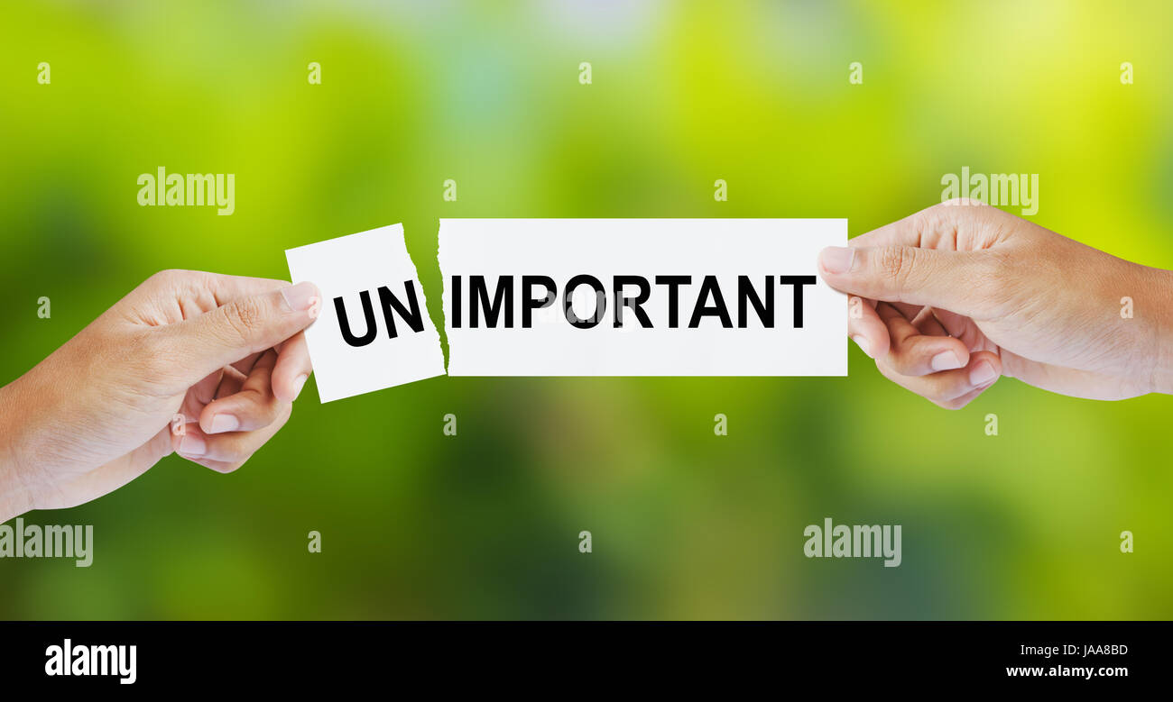 Businessman tearing the word Unimportant for Important Stock Photo - Alamy