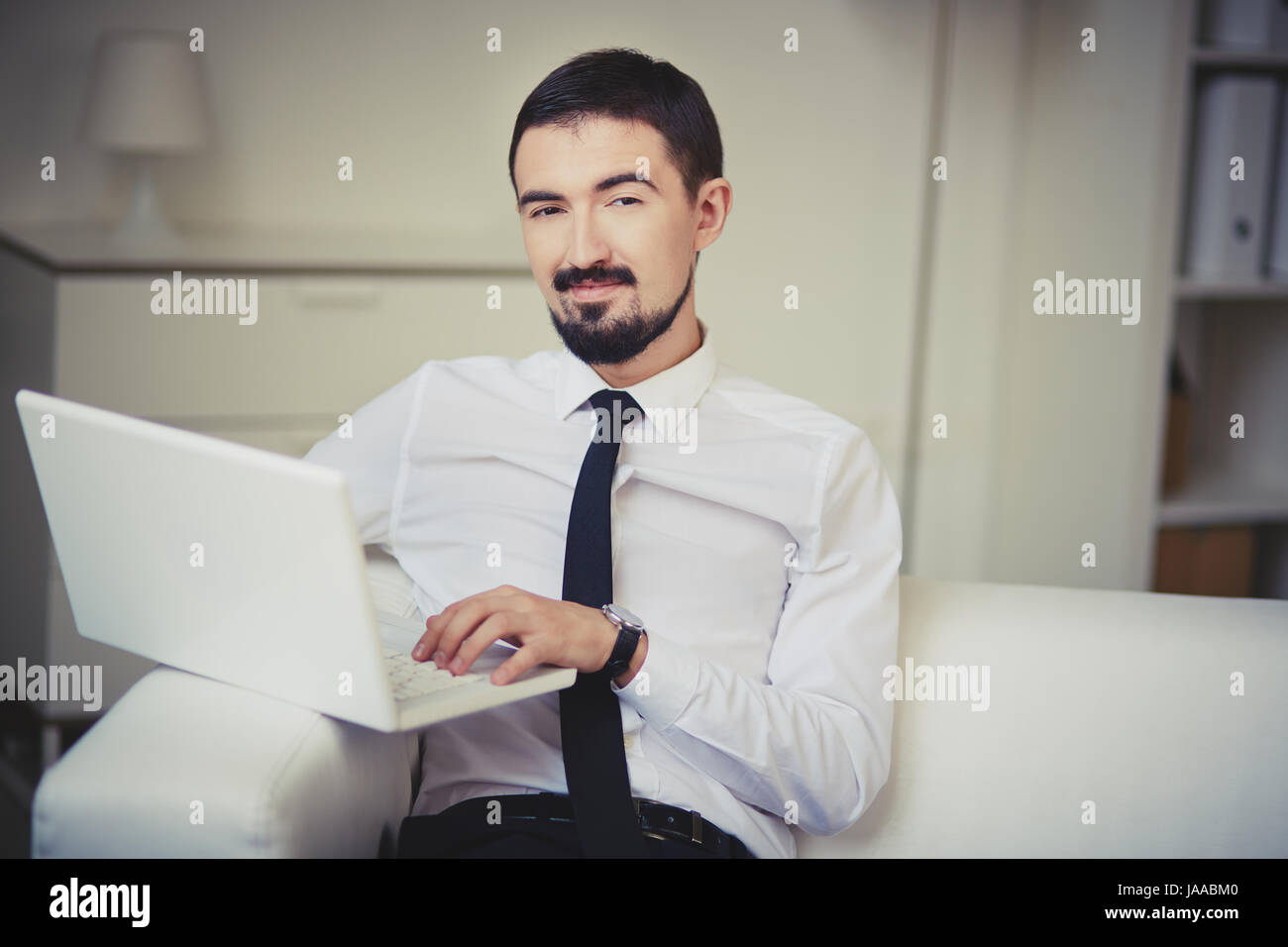 Portrait of posh guy with laptop looking at camera Stock Photo - Alamy