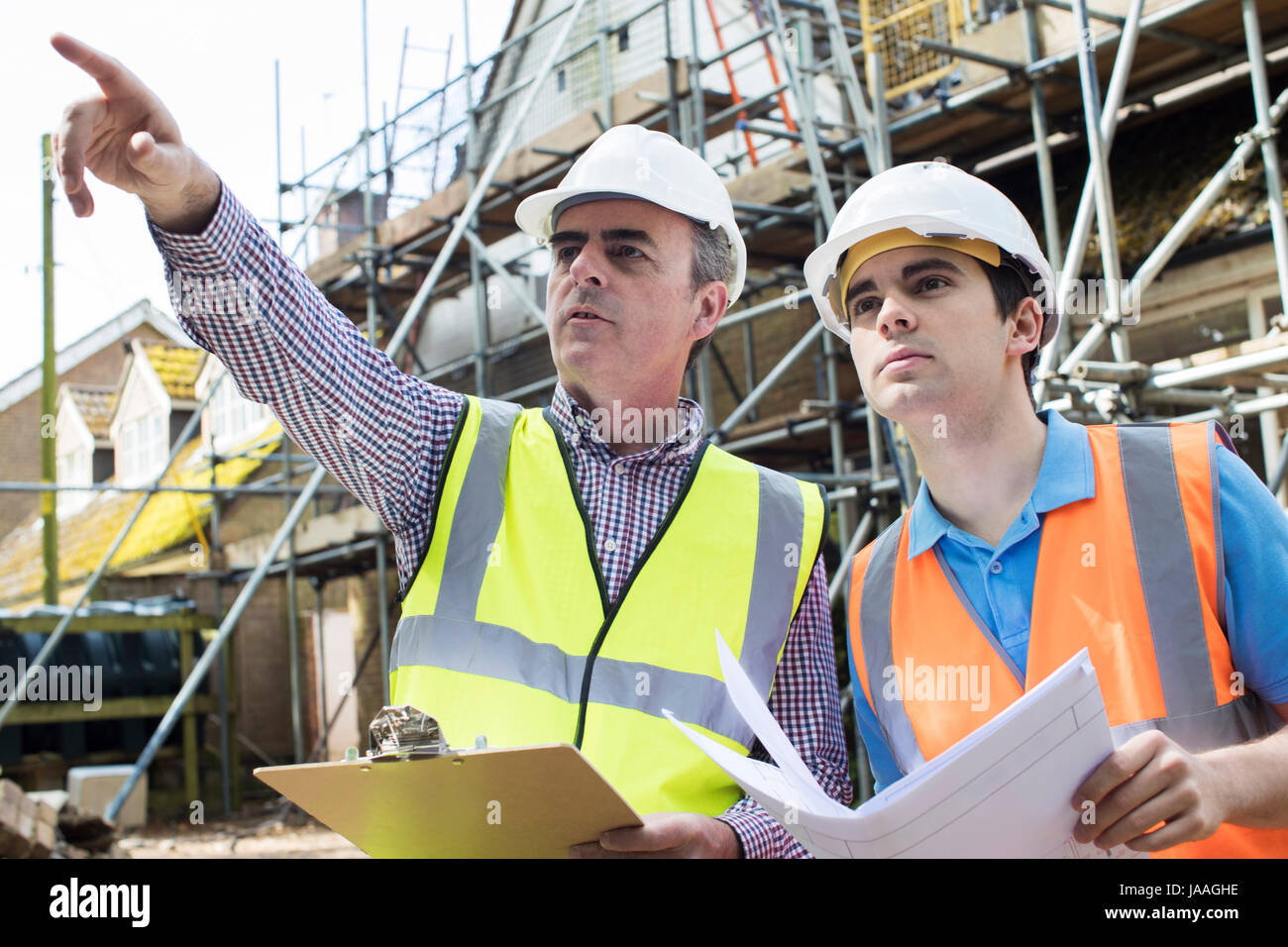 Architect On Site Discussing Plans With Builder Stock Photo - Alamy