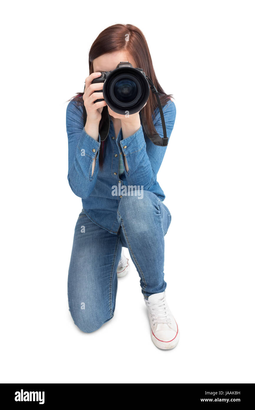 Pretty young photographer against white background taking picture of ...