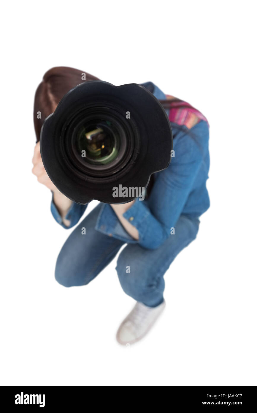 High angle view of young photographer against white background taking ...