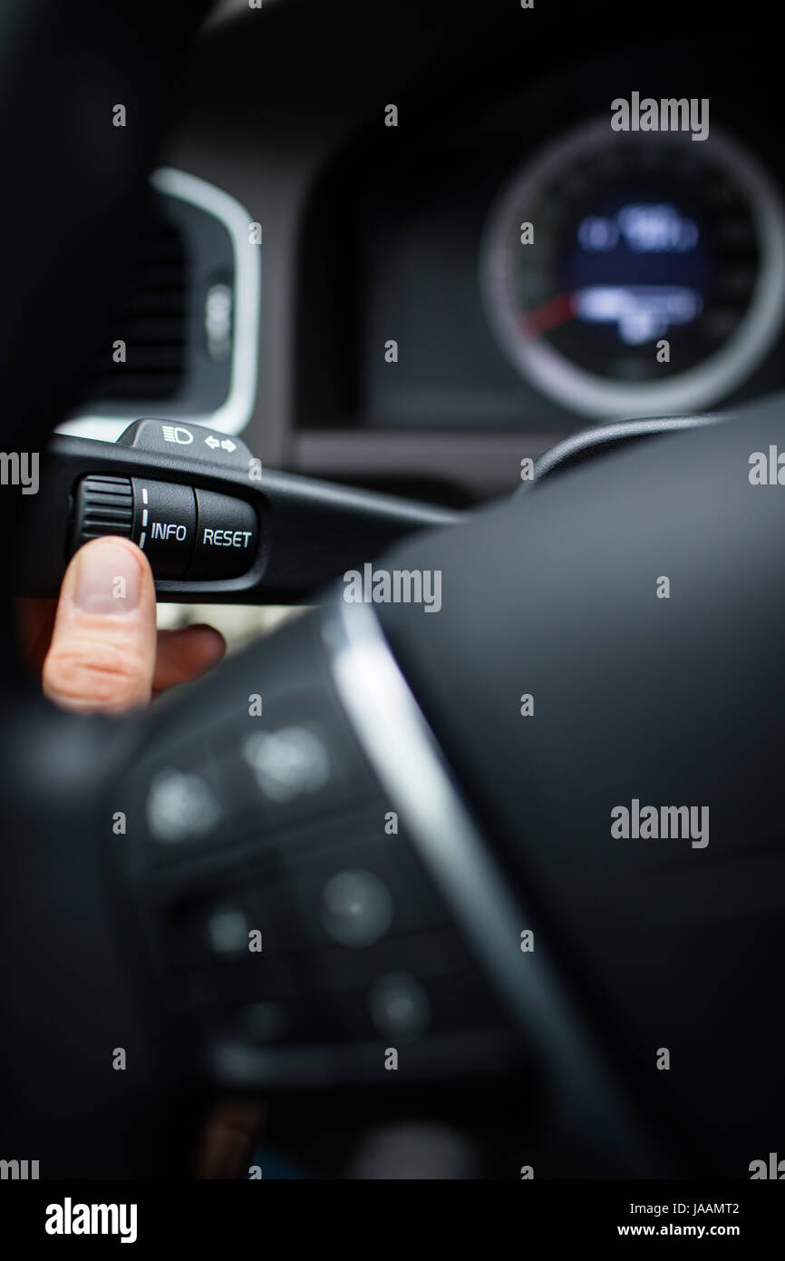 Modern car interior - driver pressing a button, using the car computer ...