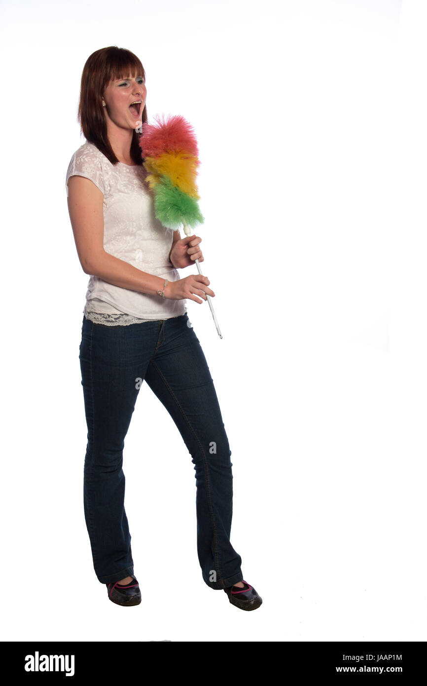 Young woman with a duster pretending to sing isolated on white ...