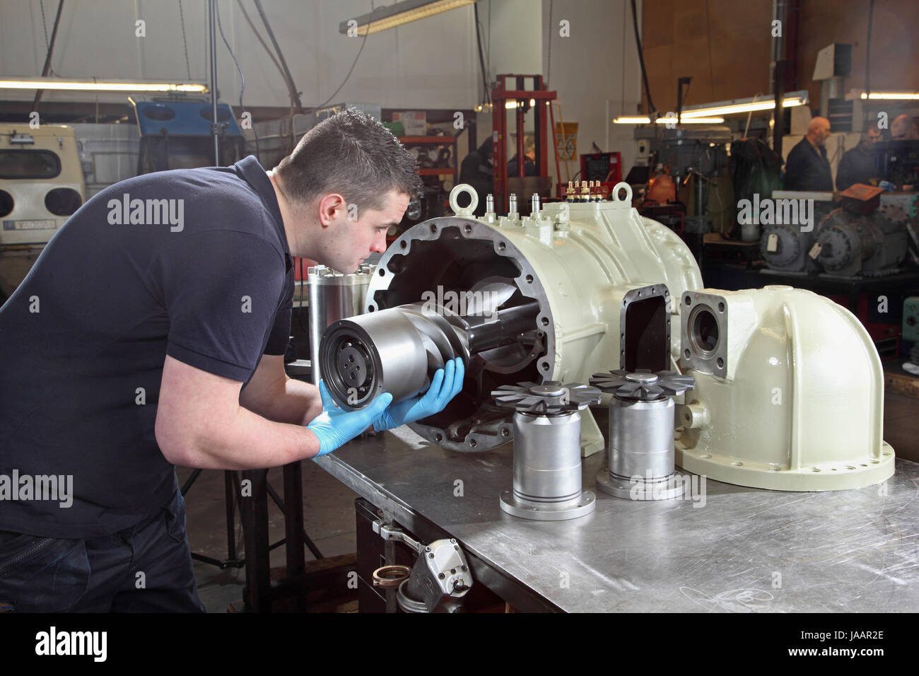 An engineer assembles an industrial compressor in a small UK factory ...