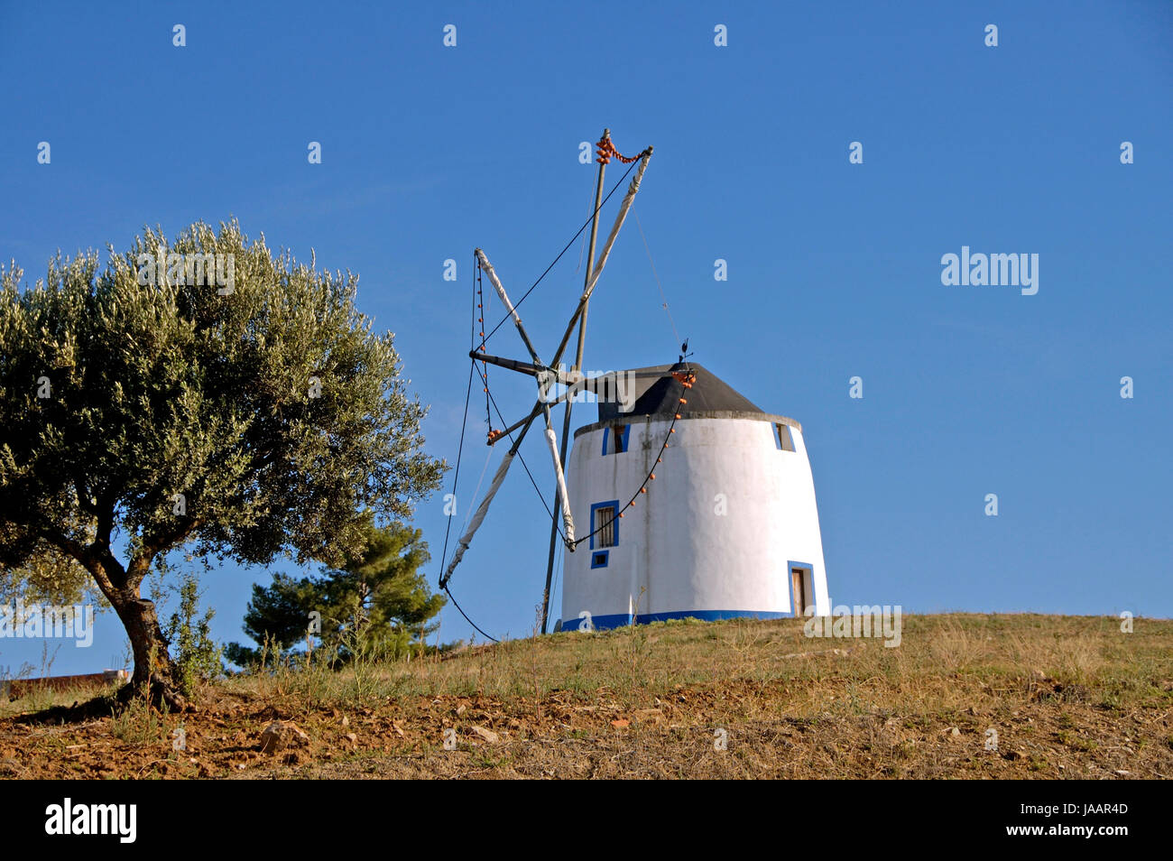 An old traditional windmill standing on top of a hill in Portugal Stock ...