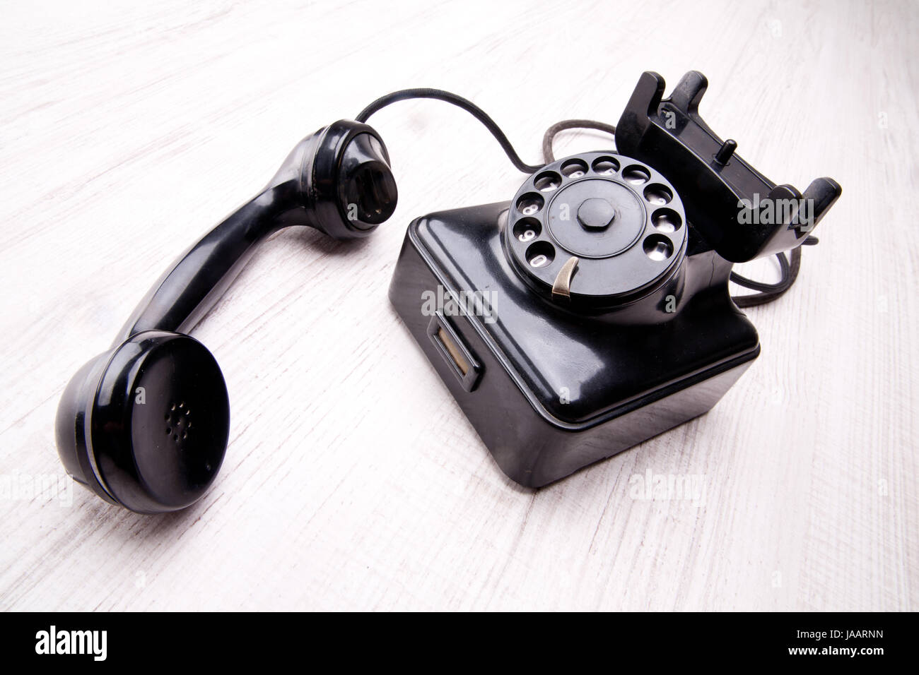 Black rotary dial telephone on a light background Stock Photo - Alamy