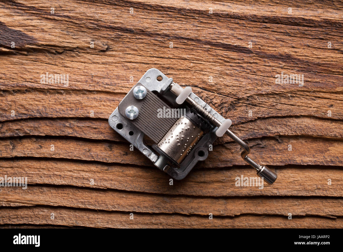 A small metallic carillon on a dark coarse-grained wooden background ...