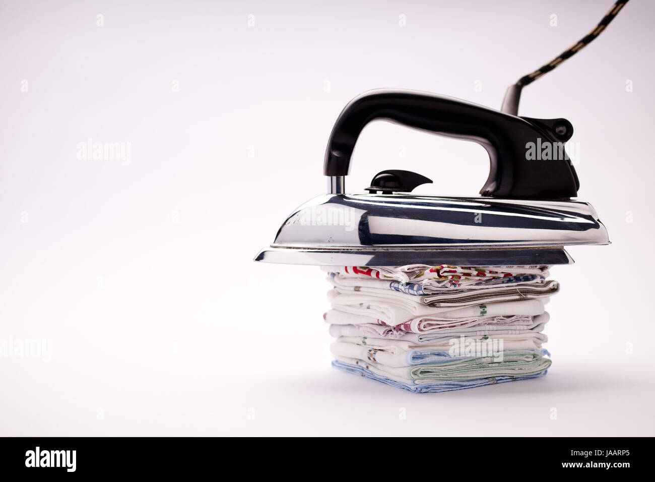 old fashioned electric iron with a black plastic handle and steel base ...