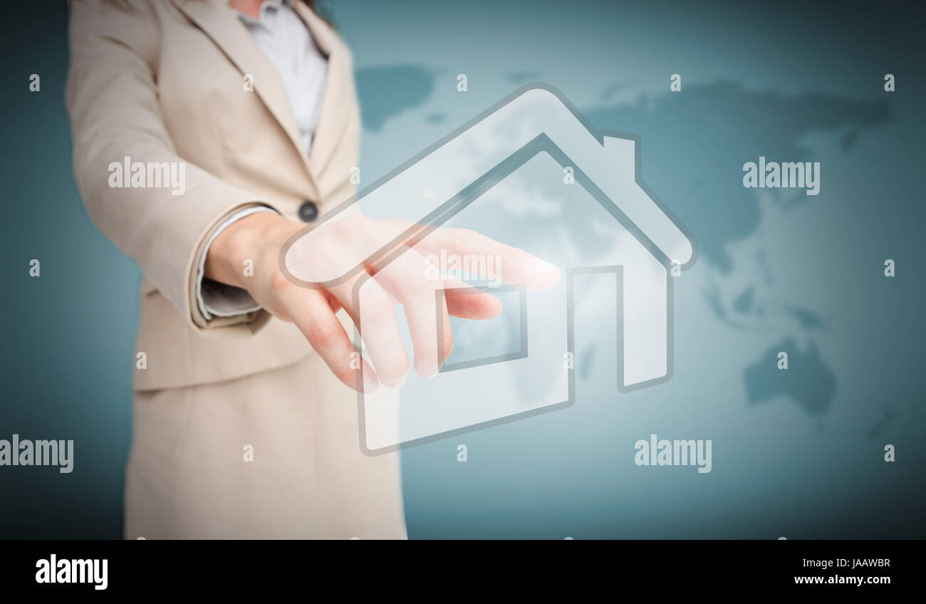 Businesswoman touching house graphic on world map background Stock ...