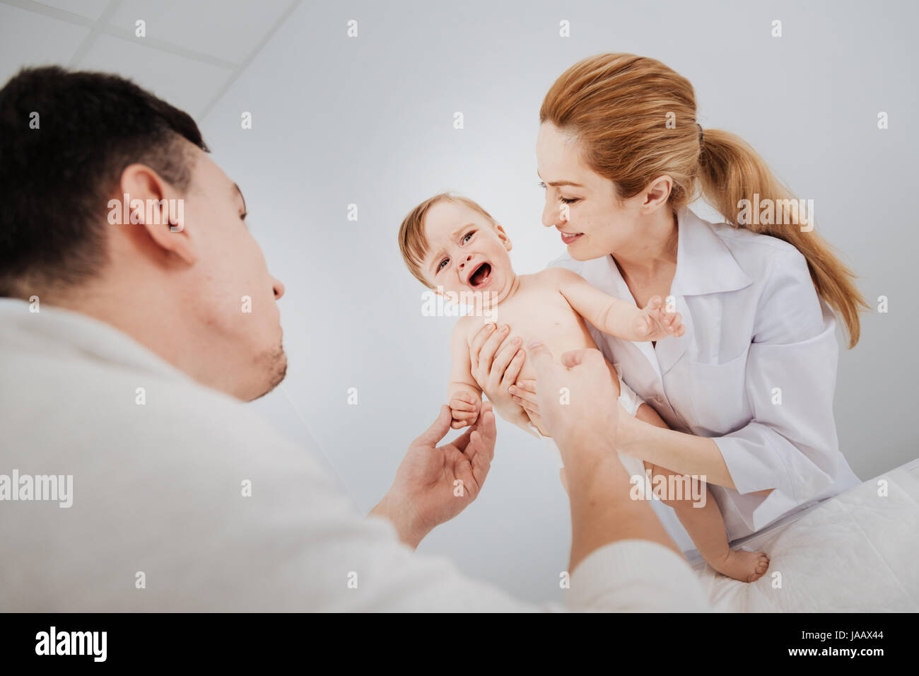 Hard to handle. Scared crying pretty child not wanting cooperating with ...