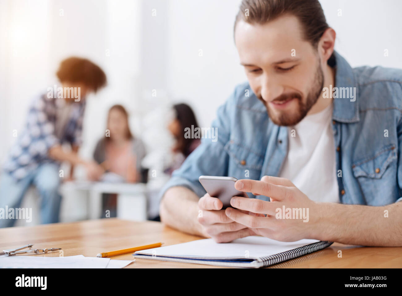 Always online. Productive bright easygoing man sitting in the class and ...