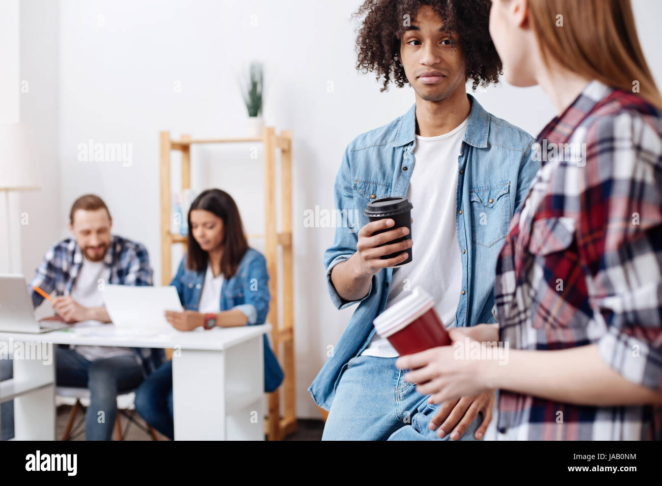 Easy going kids. Handsome nice polite guy relaxing in the office while ...