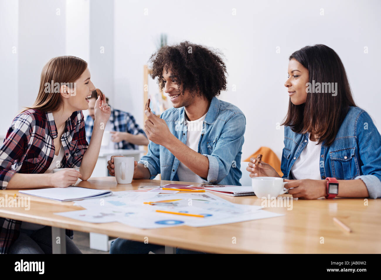 Positive vibes. Charming positive emotional people eating some snacks ...
