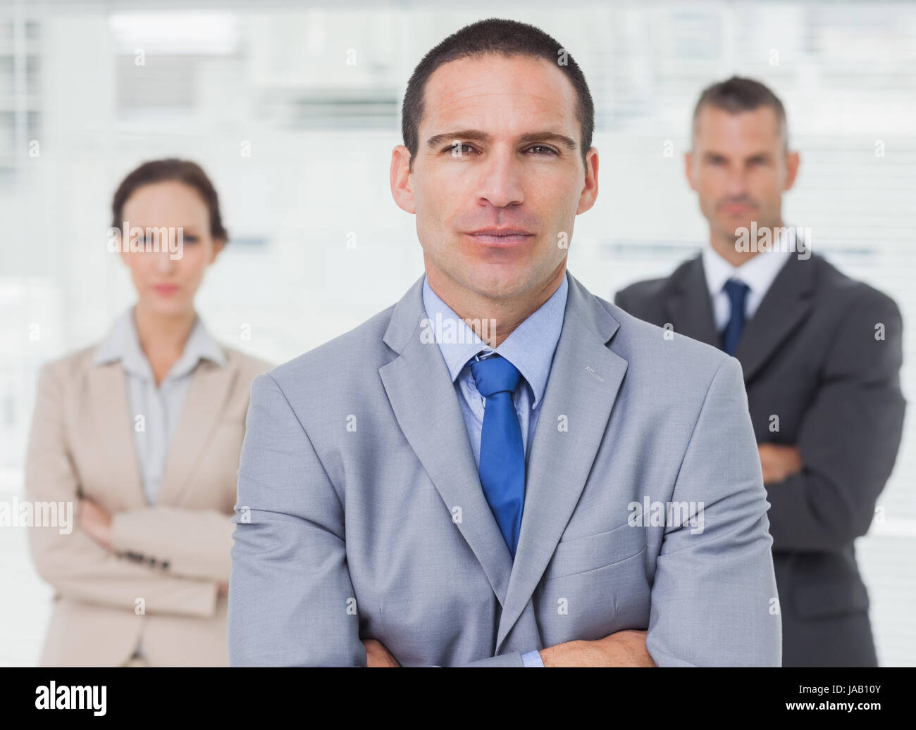 Serious employee in bright office posing with his colleagues on ...