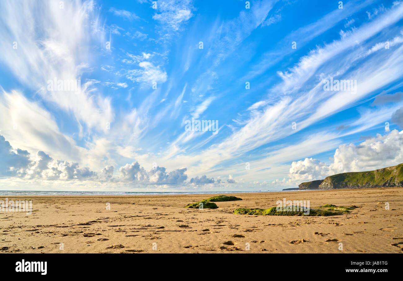 A view of the beach looking out to sea underneath a big blue sky with ...