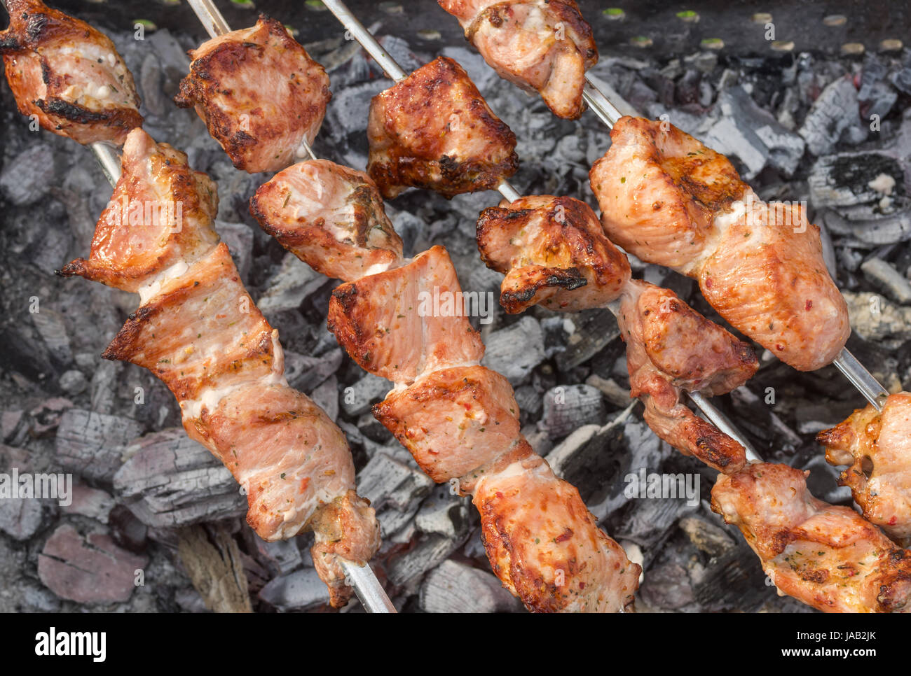 Pork meat cooking outdoor on skewers over smoldering carbon Stock Photo ...