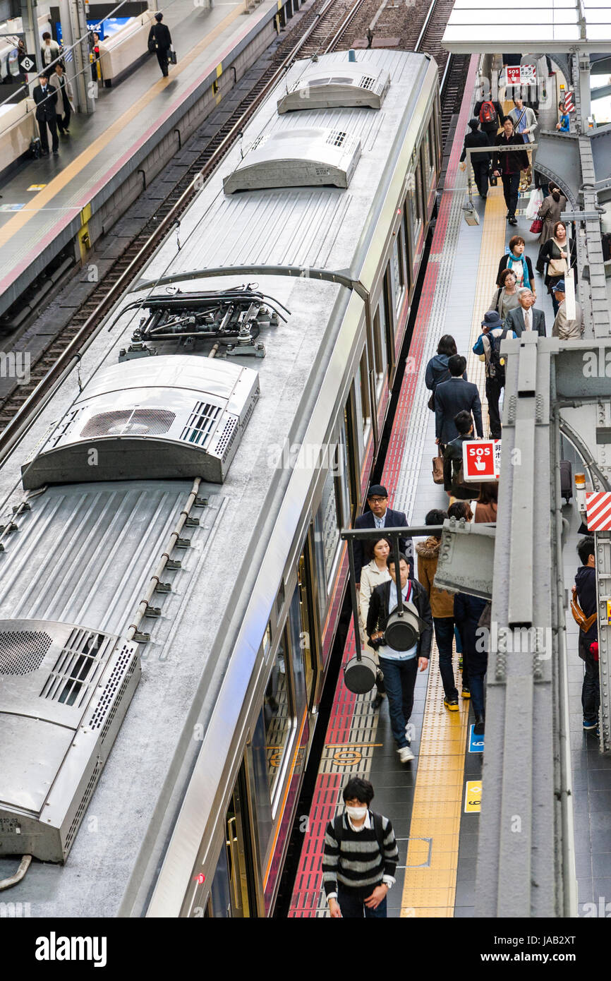 Osaka railway station. Overhead view of platform with commuter train ...