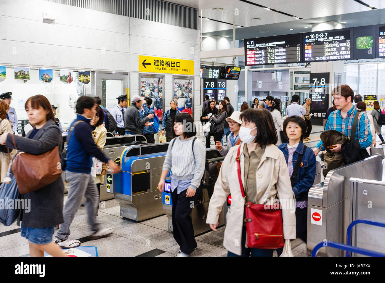 Osaka main station interior. Commuters going through automatic ticket ...