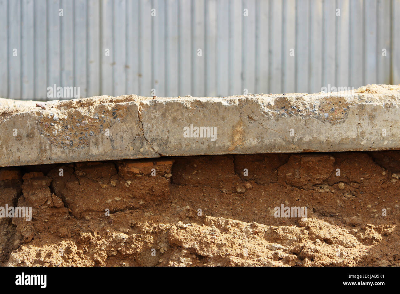 The concrete slab lies on a platform under a layer of sand. Different ...
