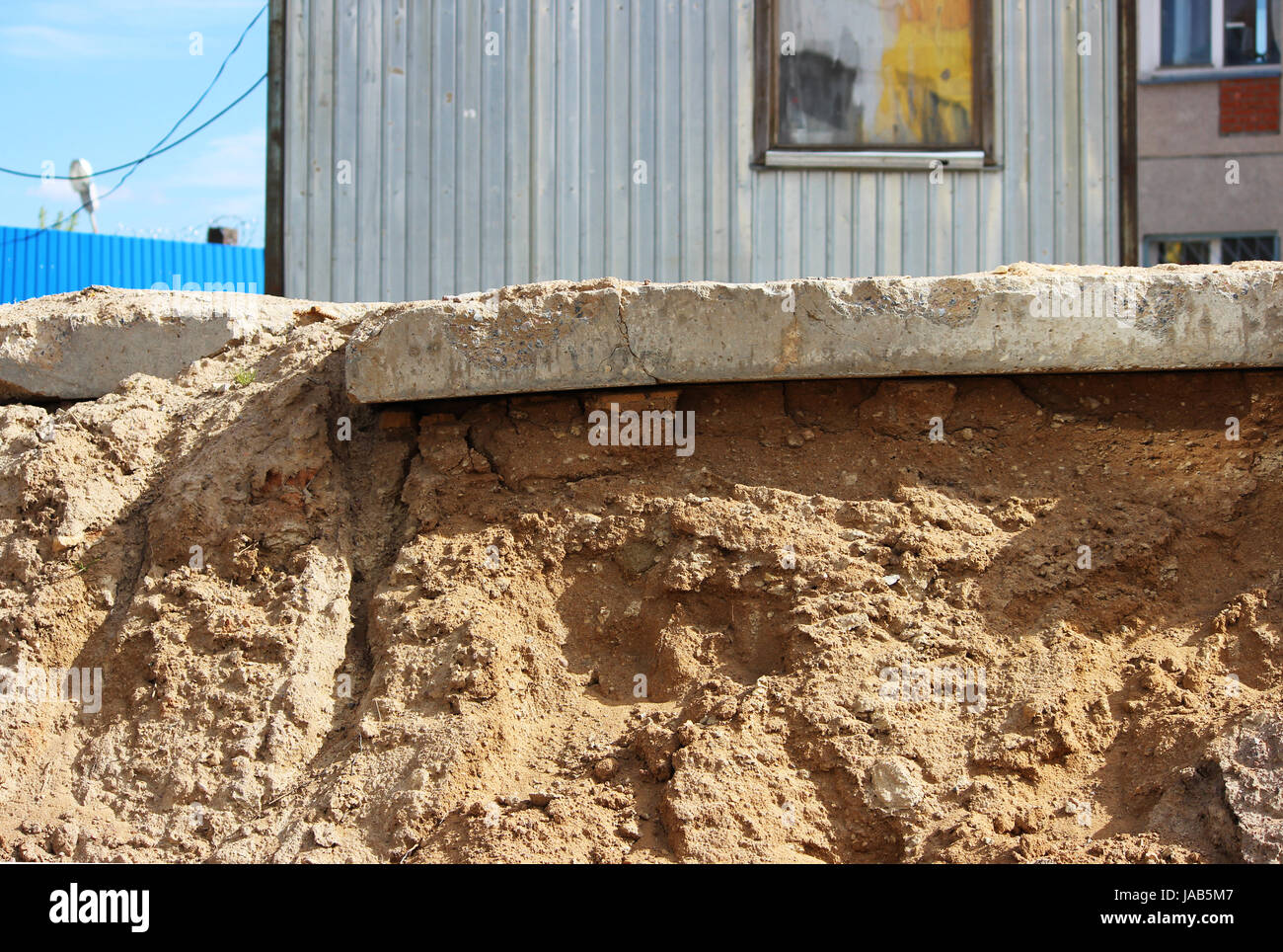 The concrete slab lies on a platform under a layer of sand. Different ...