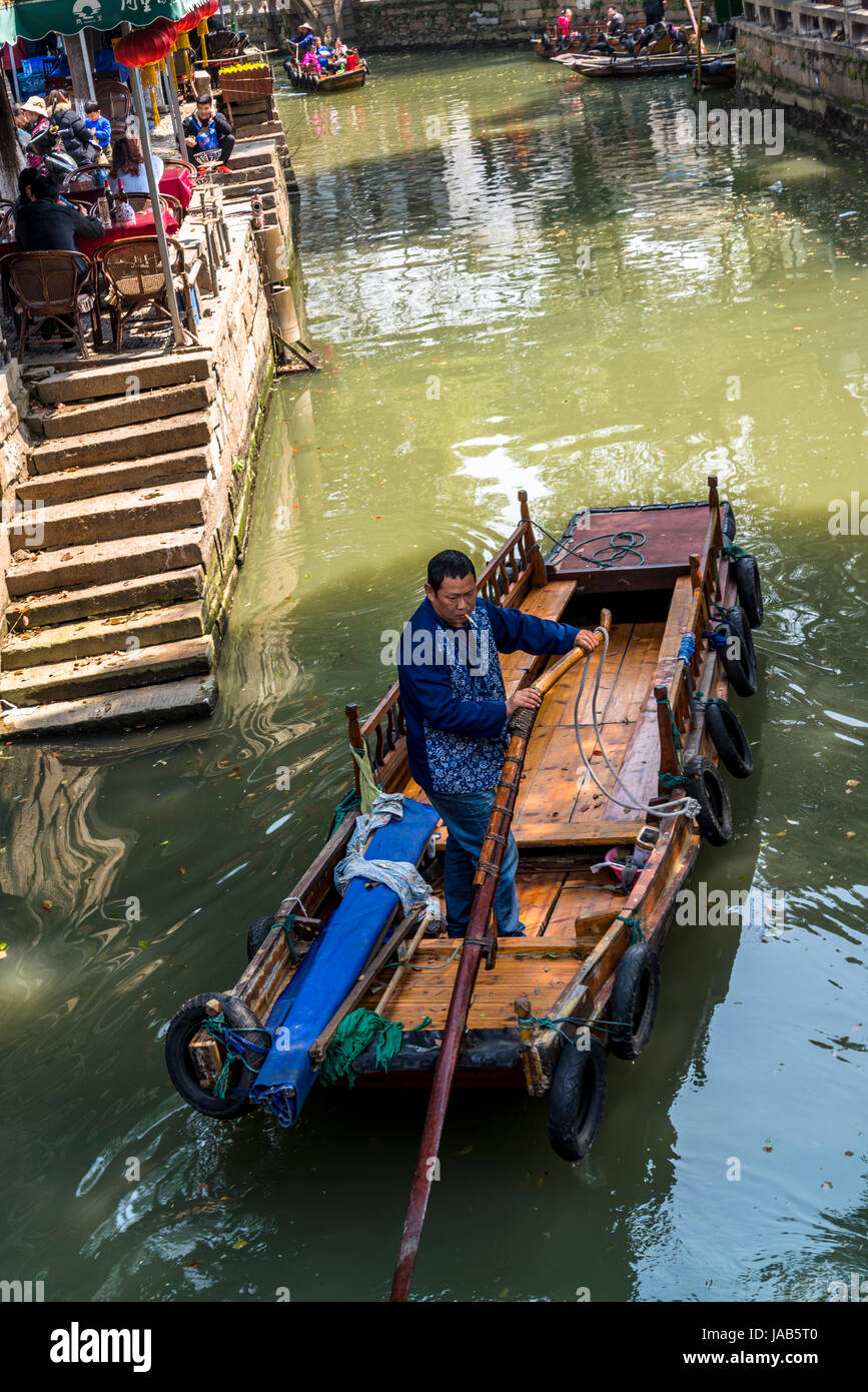 Person rowing a boat on a canal, Ancient water town of Tongli, Suzhou ...