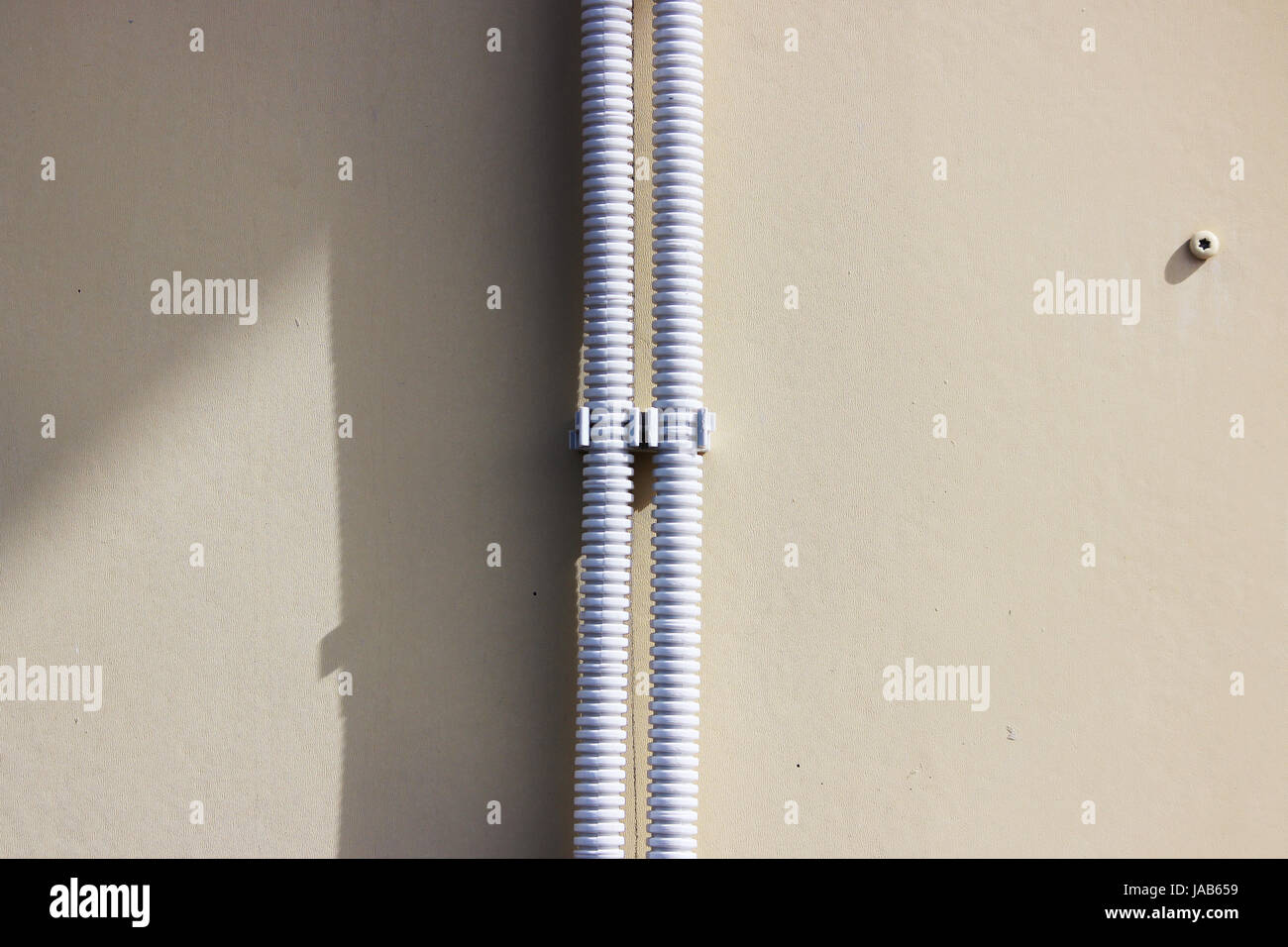 Protective white PVC corrugated pipe channels with electrical cables ...