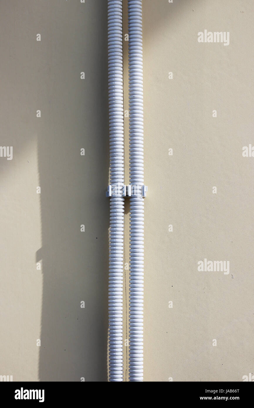 Protective white PVC corrugated pipe channels with electrical cables ...