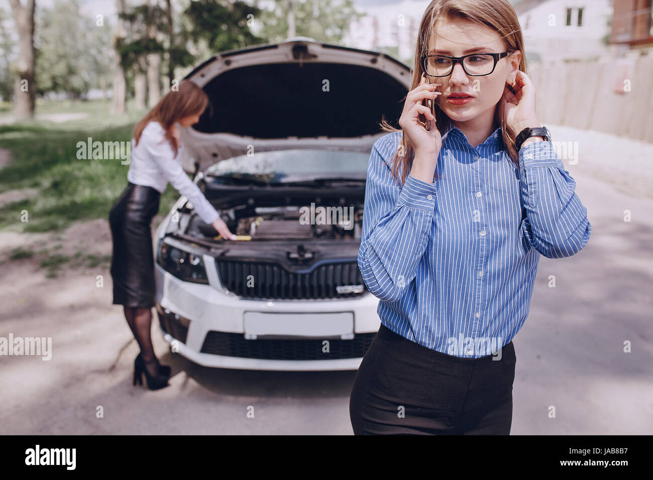 two girls on the road trying to fix their car Stock Photo - Alamy