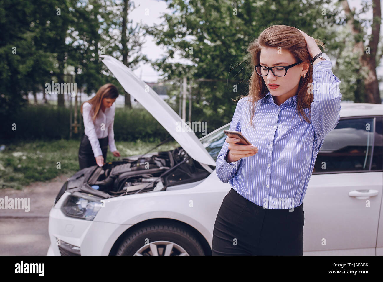 two girls on the road trying to fix their car Stock Photo - Alamy