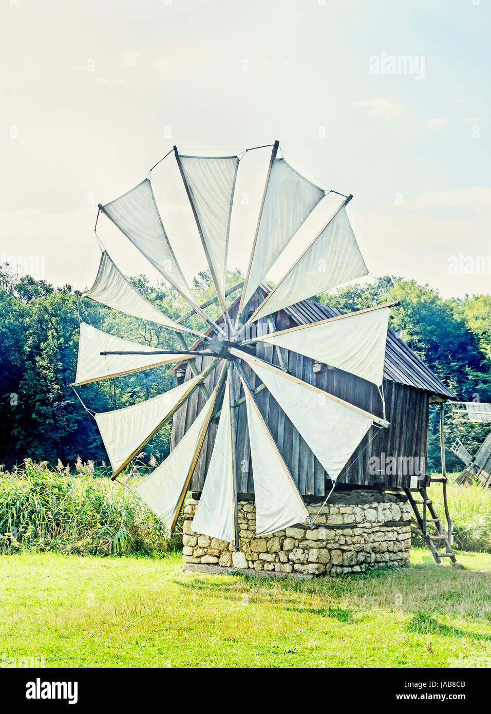 Windmill close up, green forest, wild vegetation, blue clouds sky Stock ...