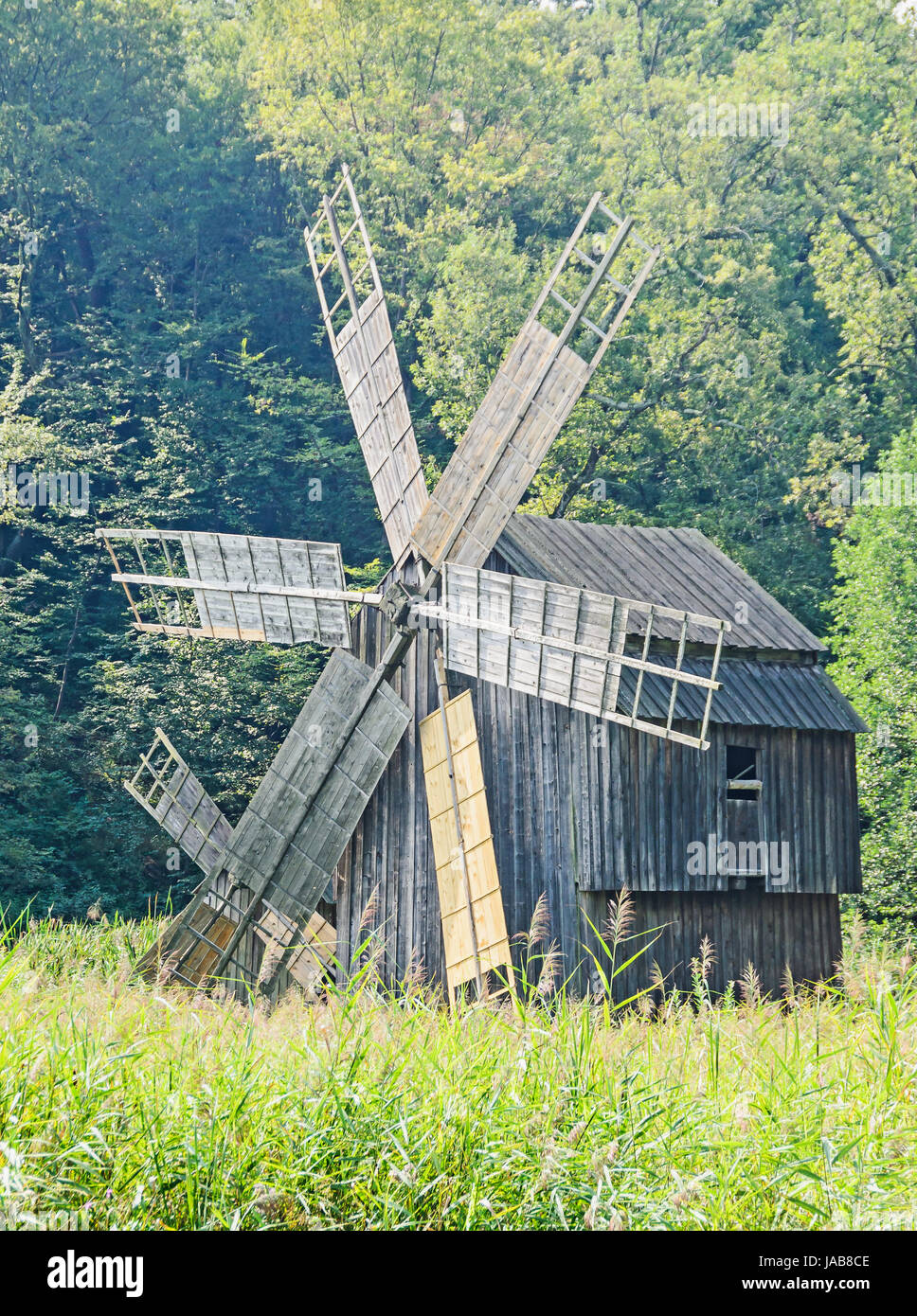 Windmill close up, green forest, wild vegetation, blue clouds sky Stock ...