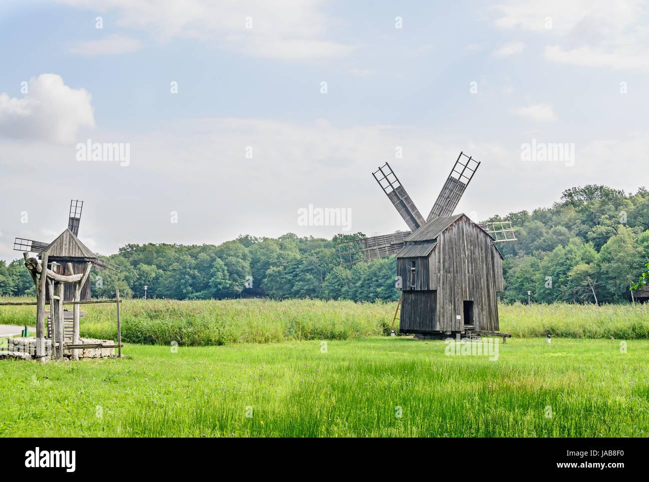 Windmill close up, green forest, wild vegetation, blue clouds sky Stock ...