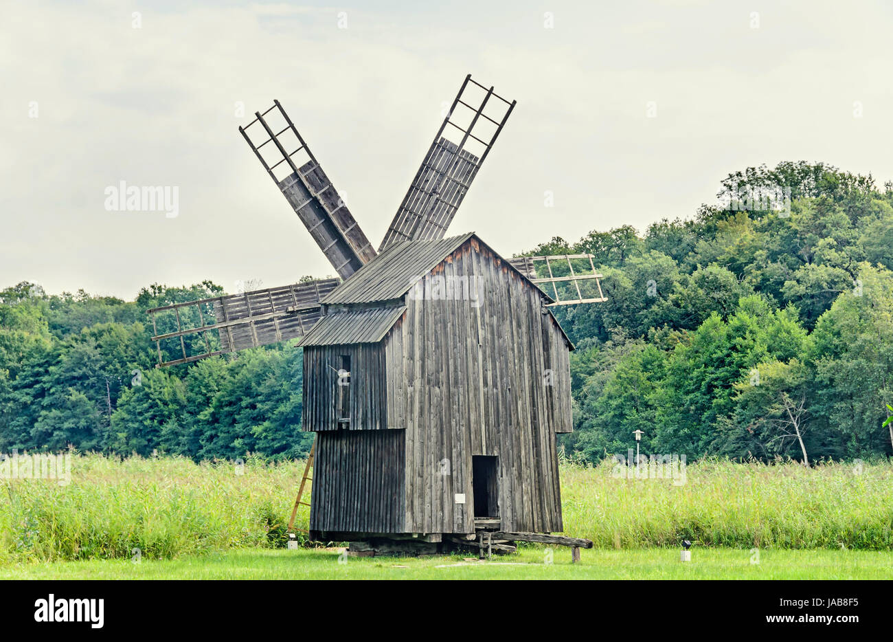Windmill close up, green forest, wild vegetation, blue clouds sky Stock ...