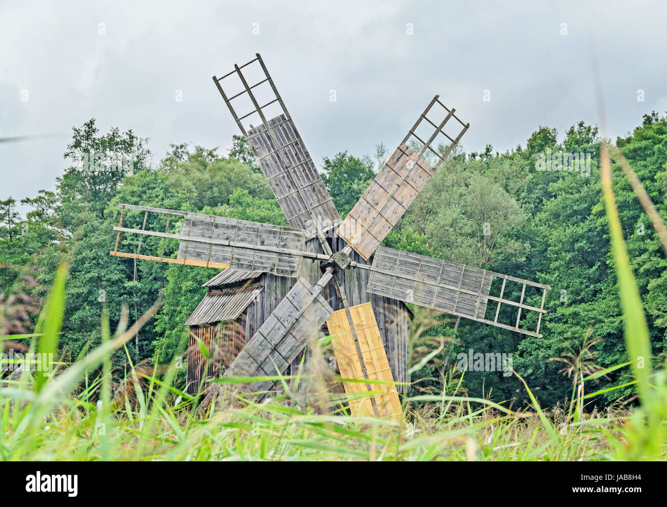 Windmill close up, green forest, wild vegetation, blue clouds sky Stock ...
