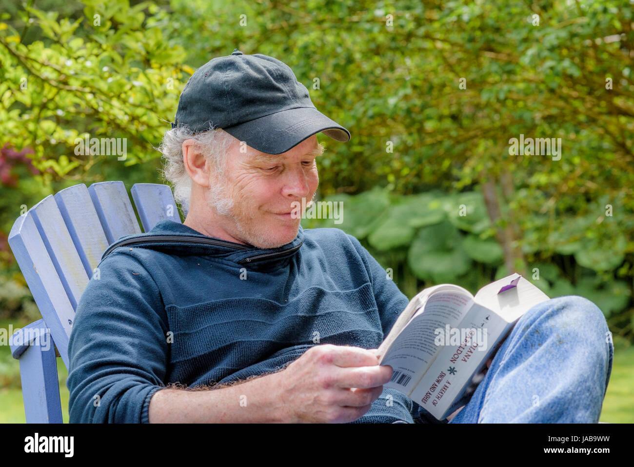man in chair reading a book Stock Photo - Alamy