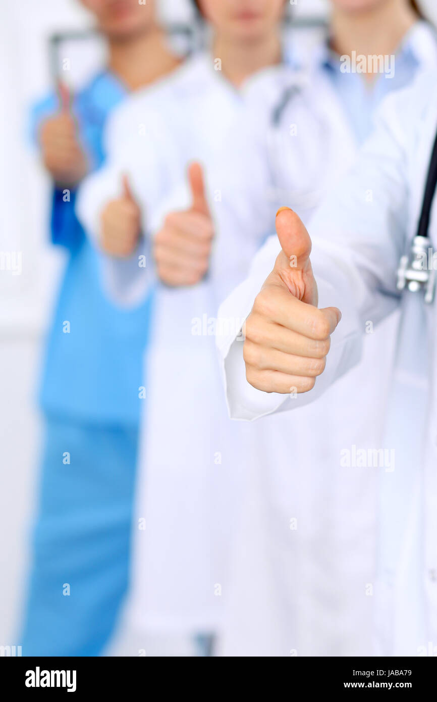 Group of doctors showing OK or approval sign with thumb up. High level ...