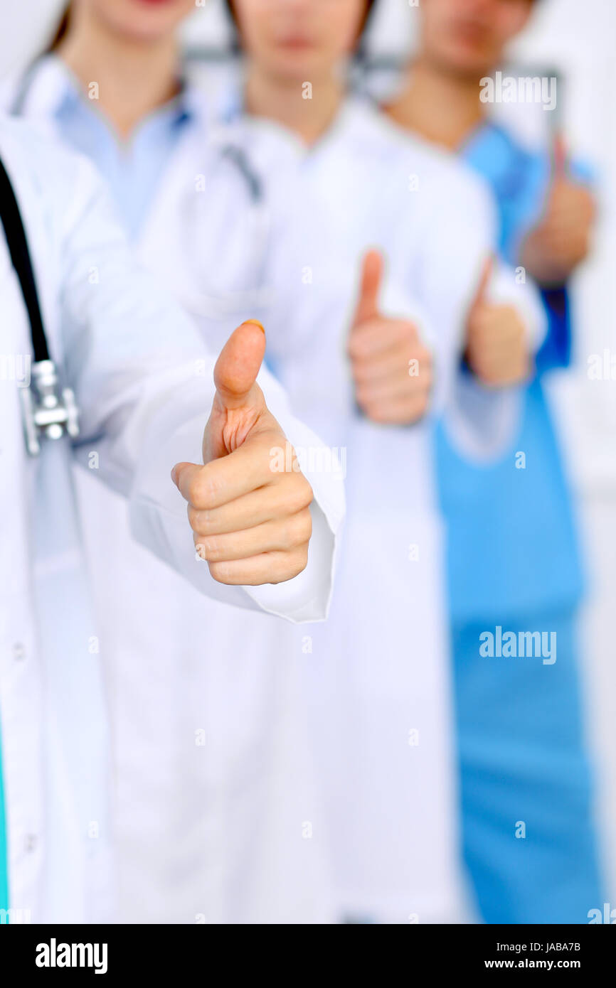 Group of doctors showing OK or approval sign with thumb up. High level ...