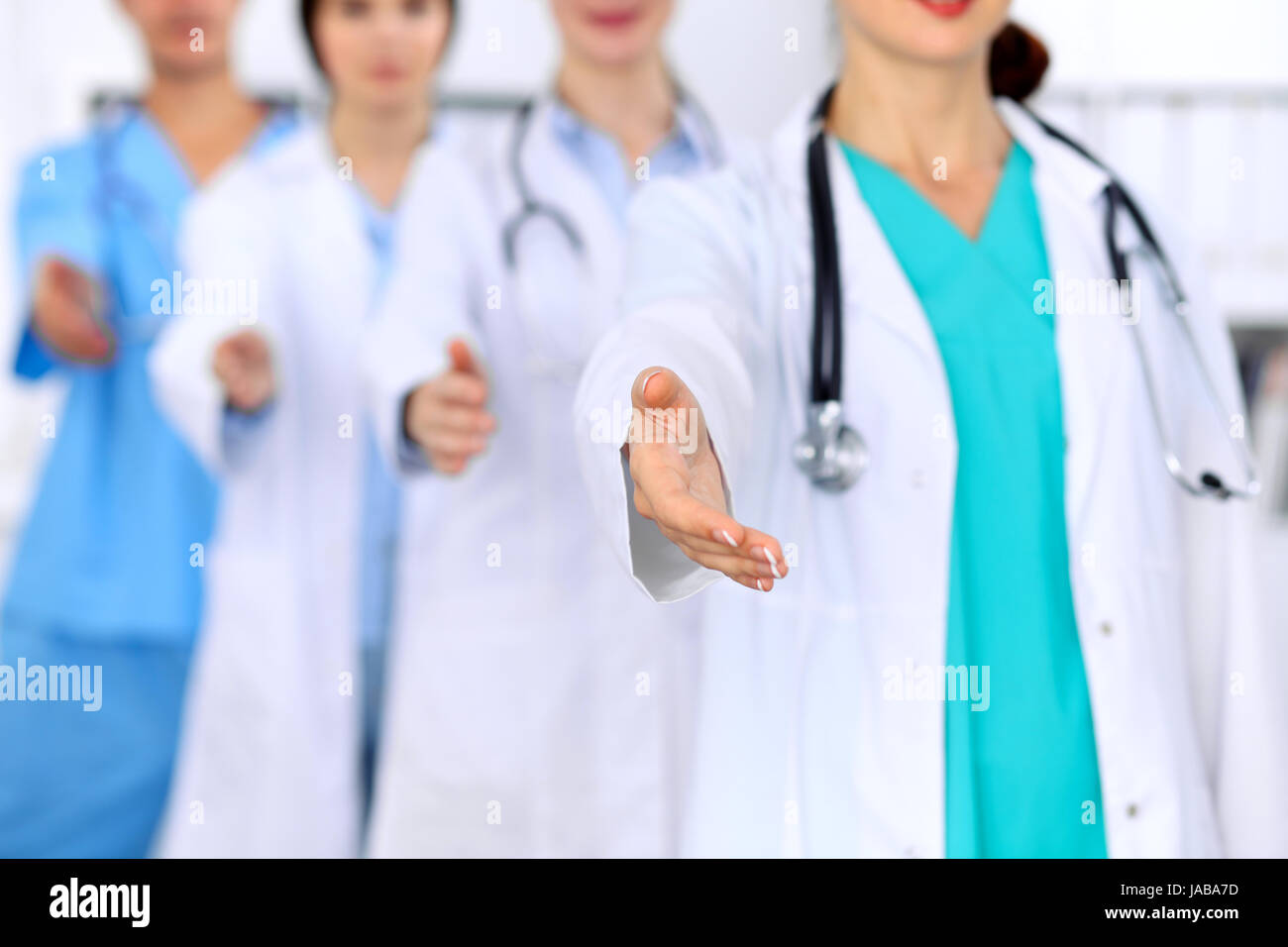 Group of doctors offering helping hand in hospital closeup. Friendly ...