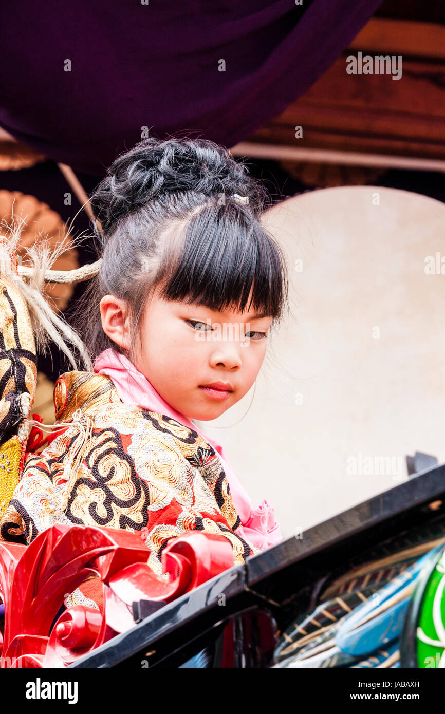 Japanese child, girl, 8-9 years old, glancing around while sitting on ...