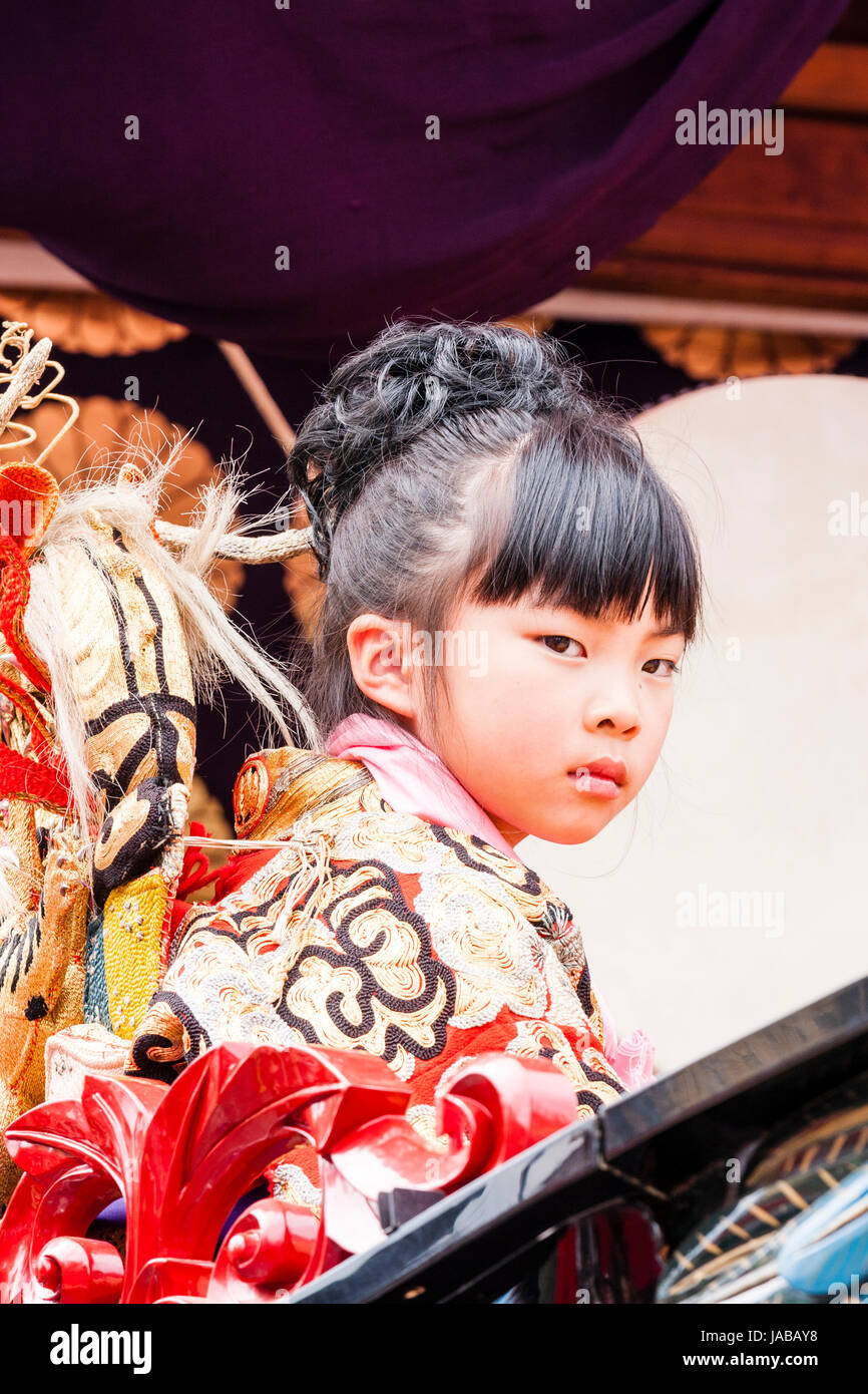 Japanese child, girl, 8-9 years old, glancing around while sitting on ...