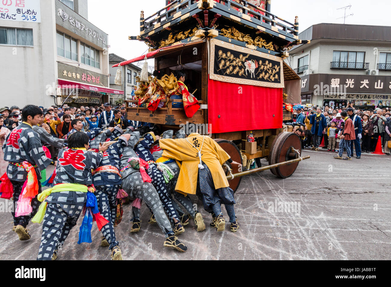 Inuyama festival in Japan. Team of men pulling and pushing to turn huge ...