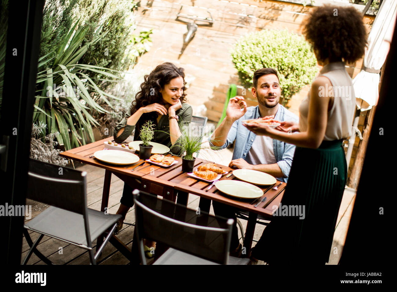 Cheerful young people have lunch in the courtyard and have a fun Stock ...