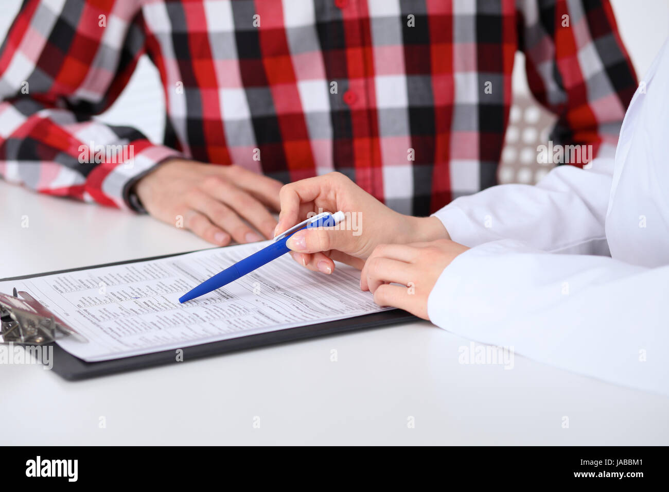Close-up of a female doctor holding application form while consulting ...