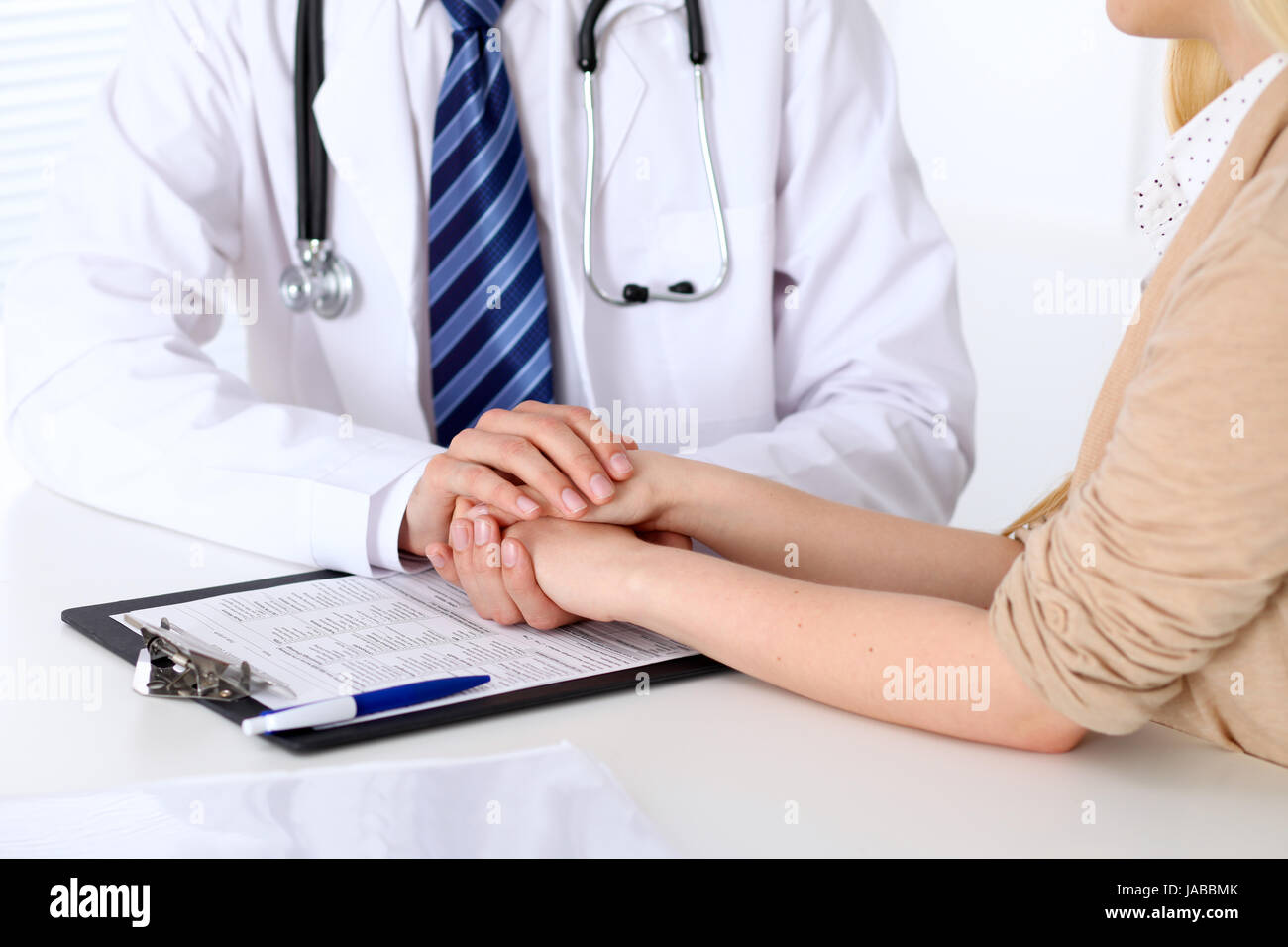 Hand of doctor reassuring her female patient. Medical ethics and trust ...