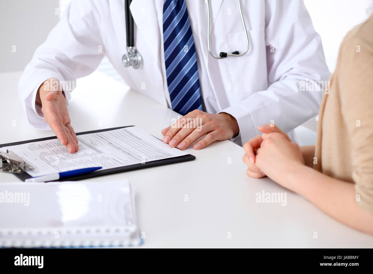 Close-up of a doctor man holding application form while consulting ...