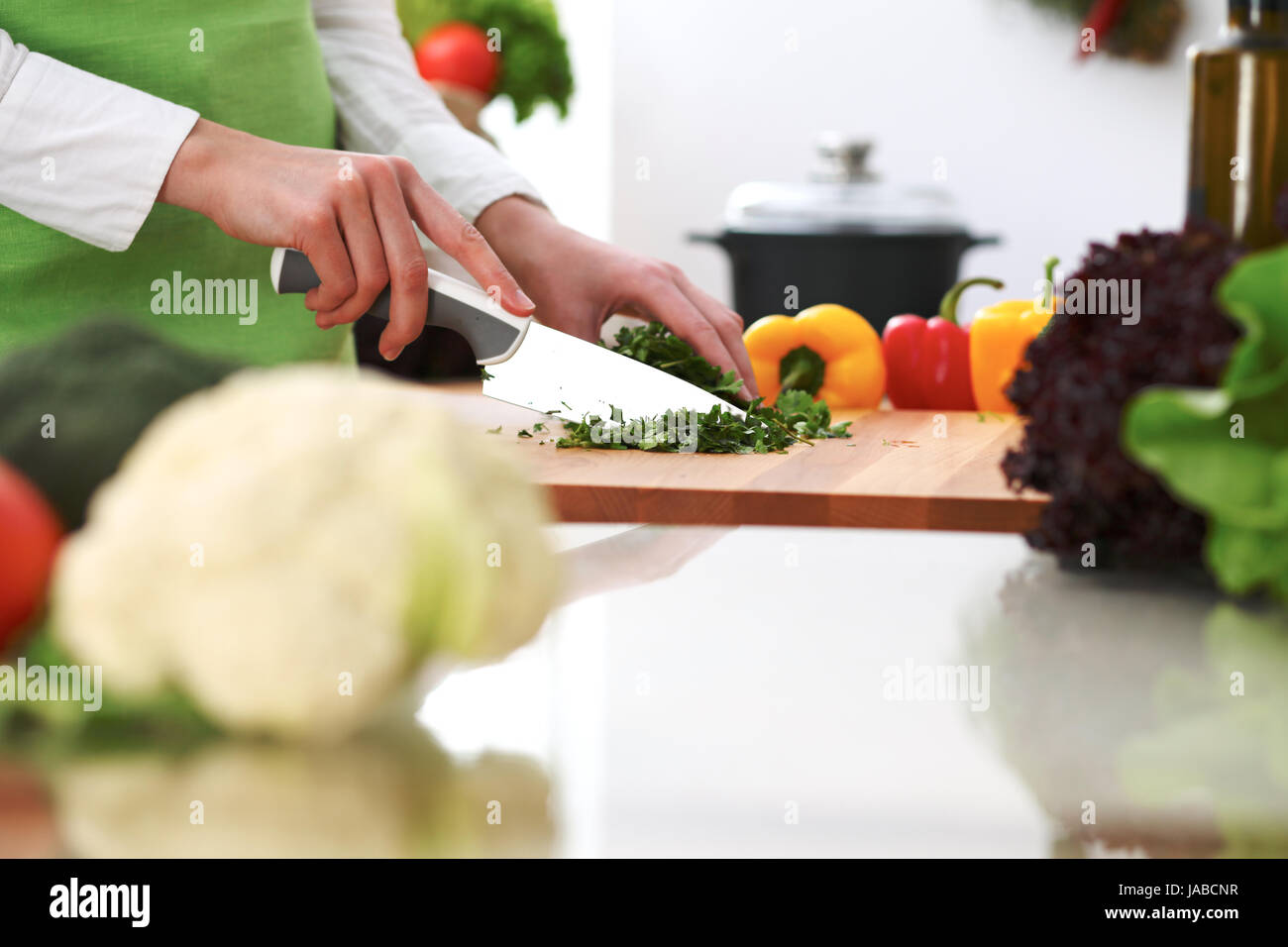Closeup of human hands cooking vegetables salad in kitchen on the glass ...