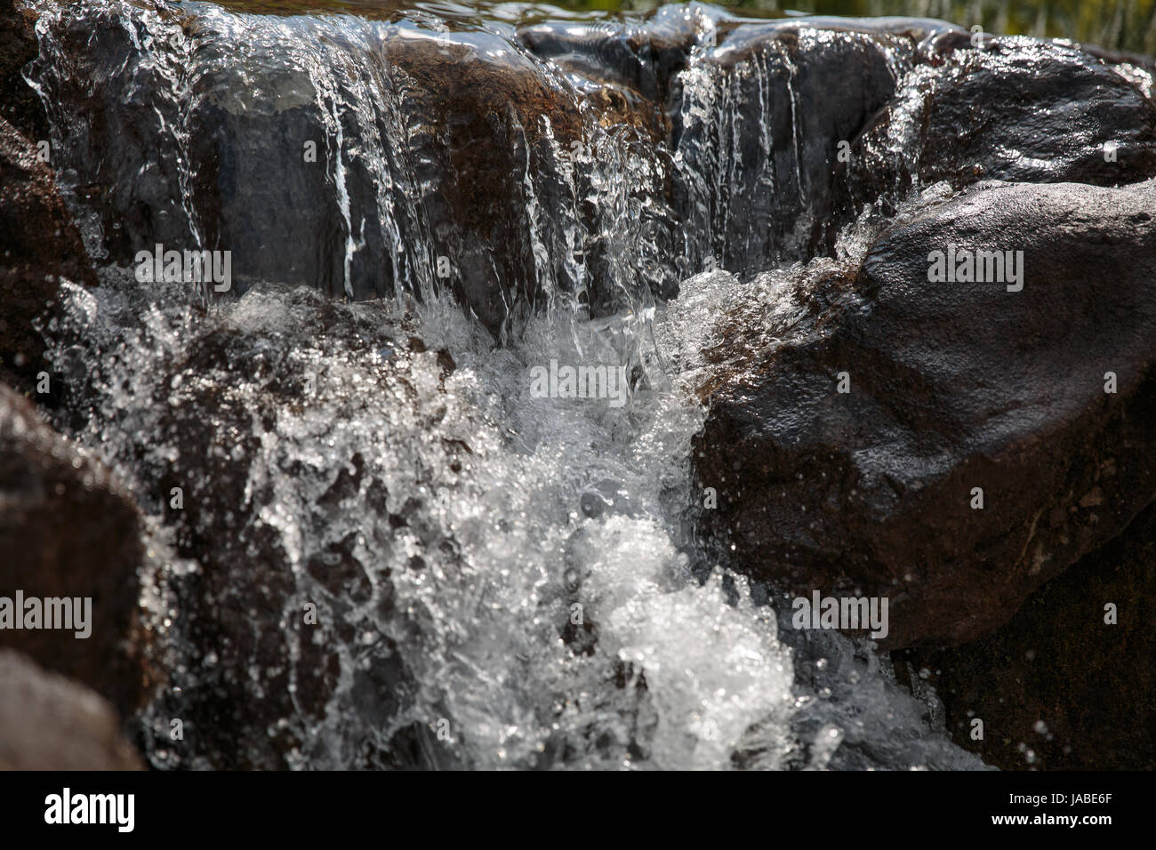 The Quick Water on the black rocks Stock Photo - Alamy