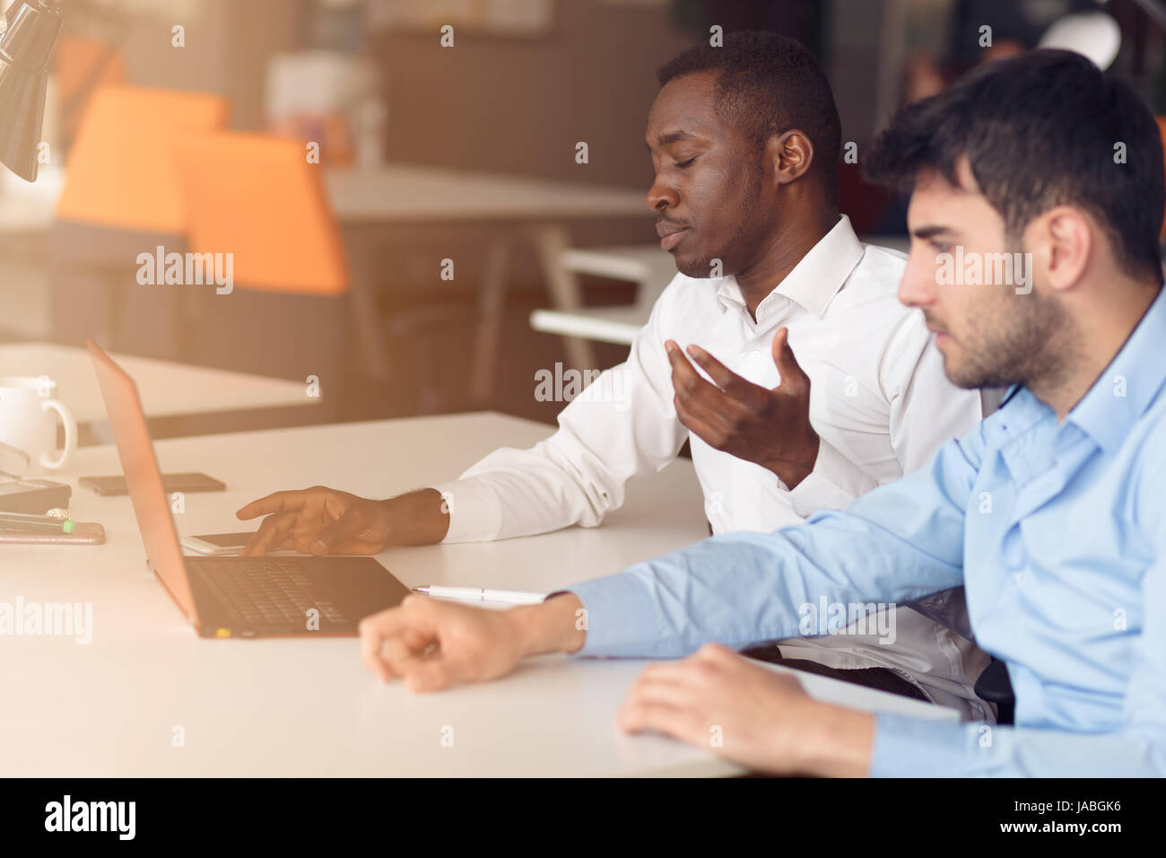 Image of two young businessmen interacting at meeting in office Stock ...