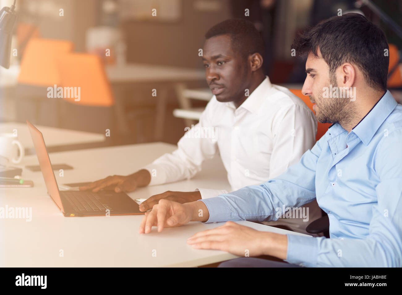 Image of two young businessmen interacting at meeting in office Stock ...